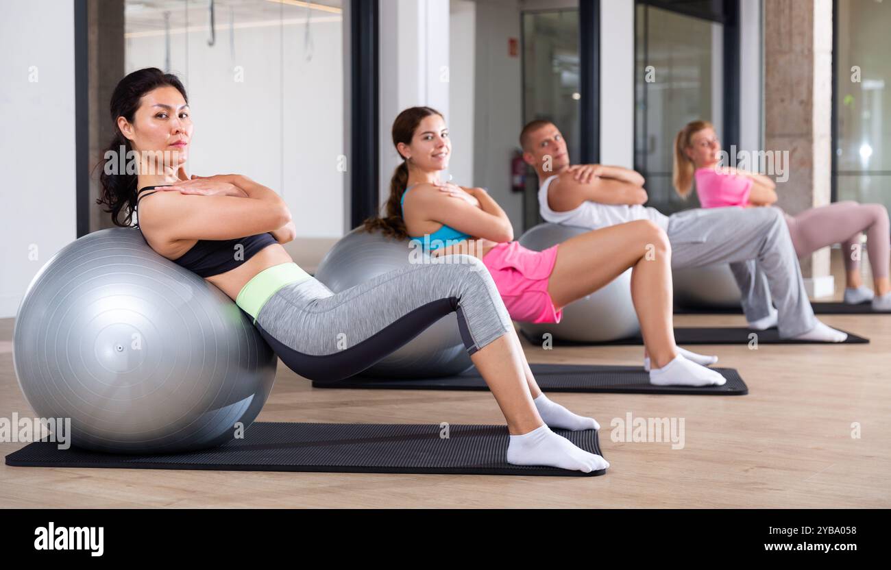 People doing roll ups on fitness balls Stock Photo - Alamy