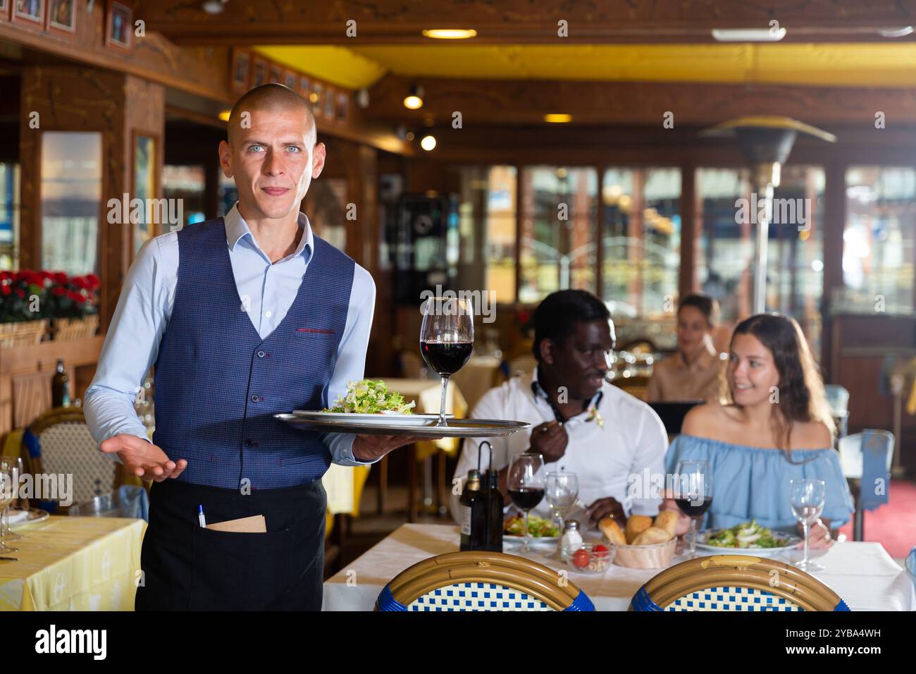 Waiter standing with serving tray, recommending dishes in restaurant ...