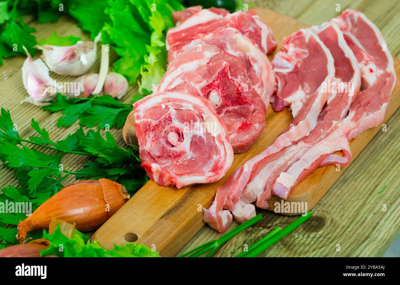 Fresh slices of mutton and vegetables assortment on natural wooden desk ...