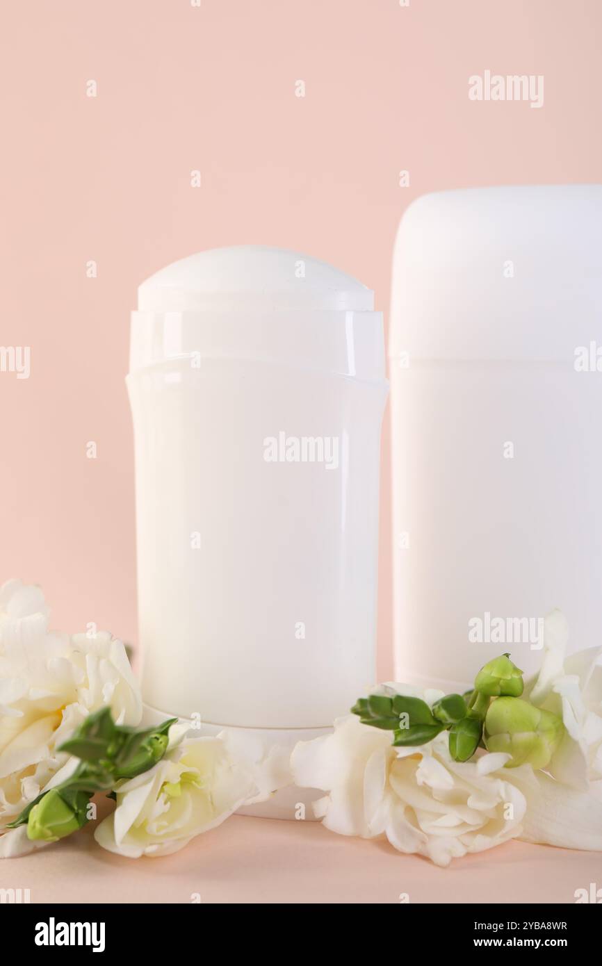 Solid deodorants and beautiful eustoma flowers on beige background ...