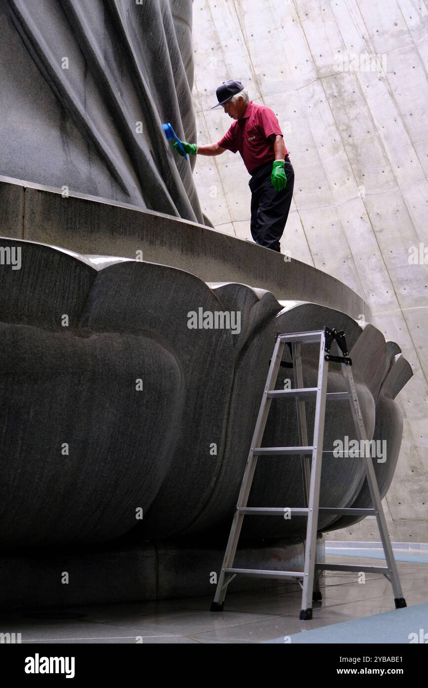 A maintenance worker cleaning the Buddha statue in the Hill of the ...