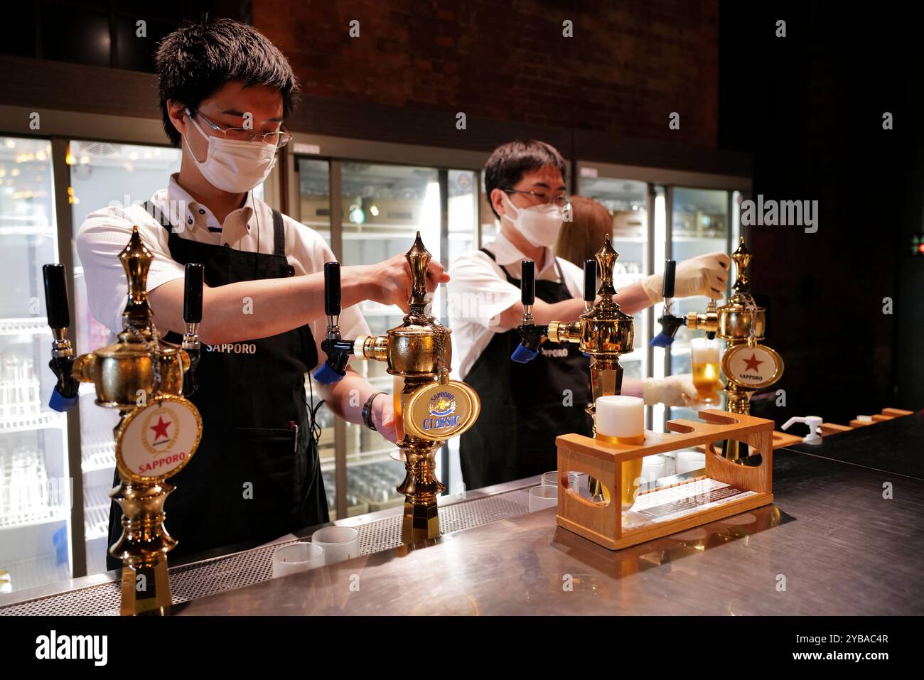 Workers pouring beer for visitors in Star Hall the paid testing hall in ...