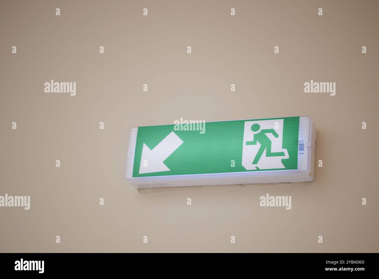 An Illuminated Emergency Exit Sign featuring a Left Arrow positioned in ...
