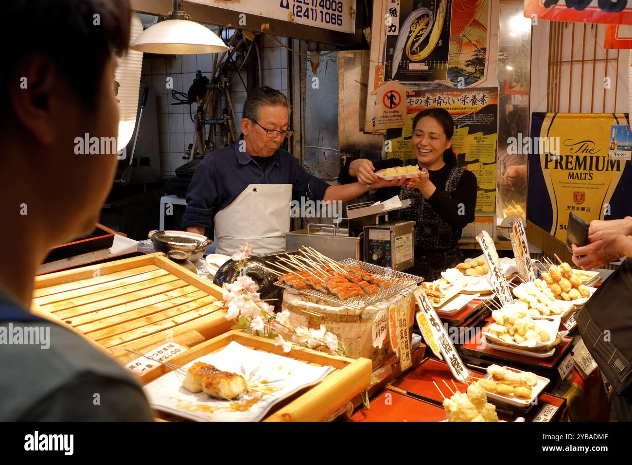 A vendor selling roasted eels and other roasted seafood in Nishiki ...