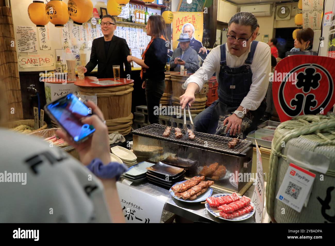 A chef making Yakiniku a Japanese type of grilled skewered meat for a ...