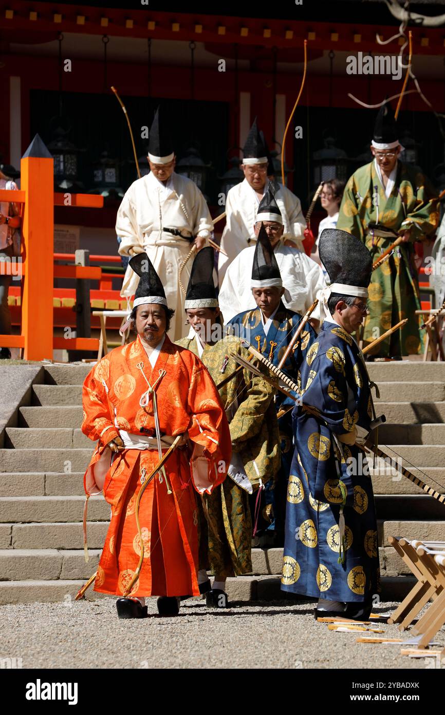 Male archers in traditional ceremonial robe and head piece entering the ...