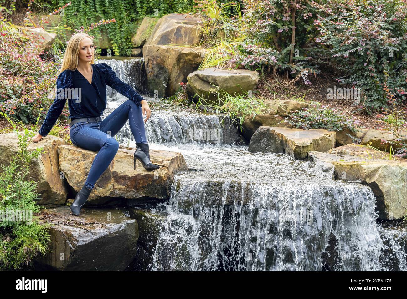 Blonde beauty shines in stunning fall attire near park waterfall, a ...