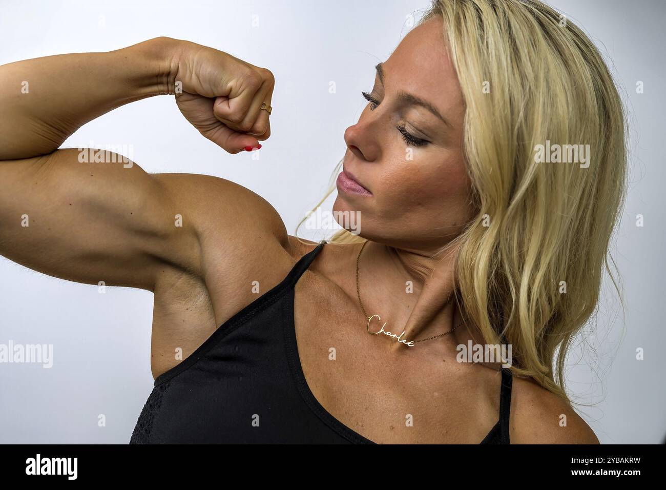 A gorgeous athletic fit model poses confidently in a studio, her toned ...