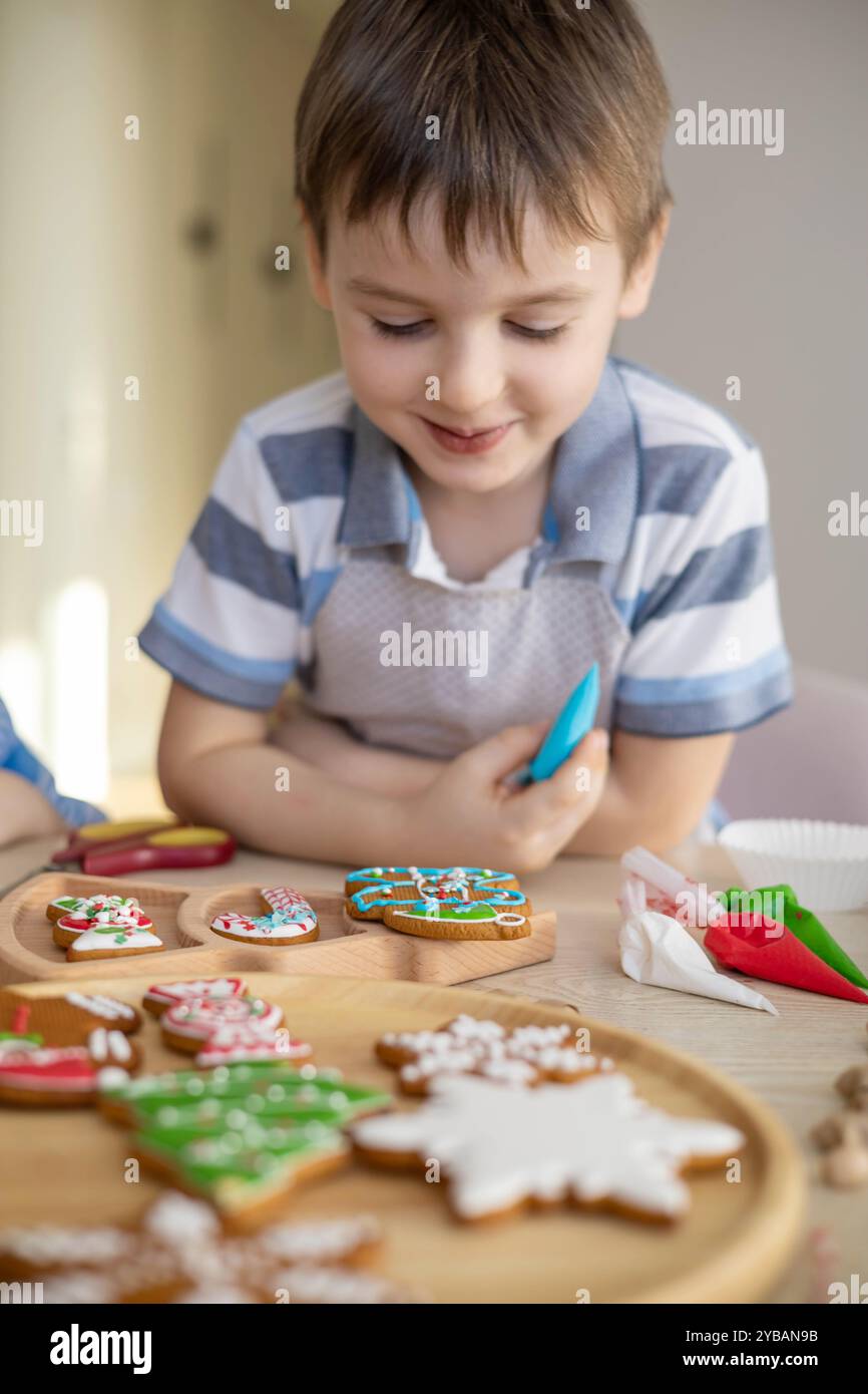 Merry Christmas and Happy Holidays. Boy cooking Christmas gingerman ...