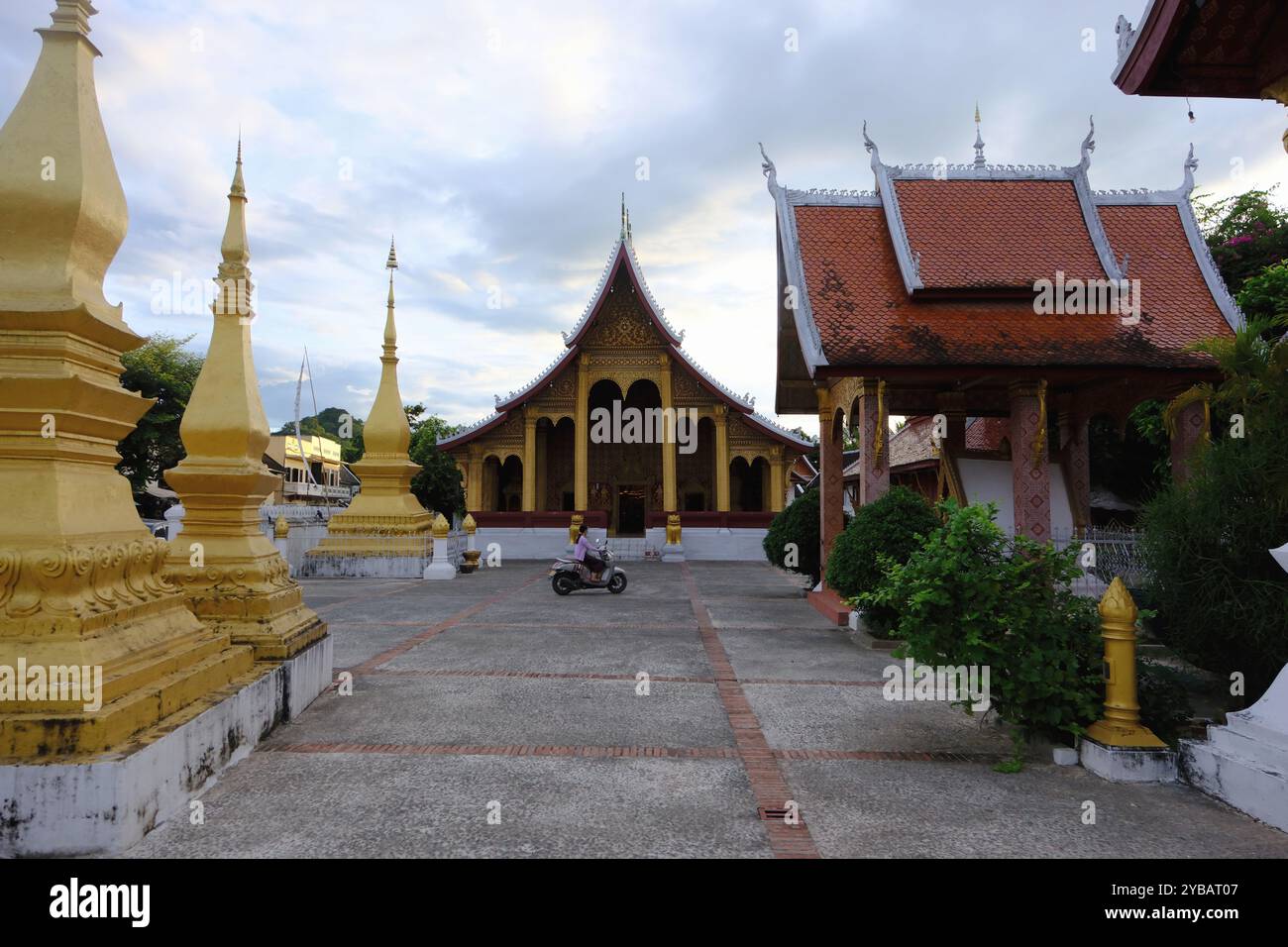 A woman riding a motorbike in Wat Sen Souk Haram temple aka Wat Sen, a ...