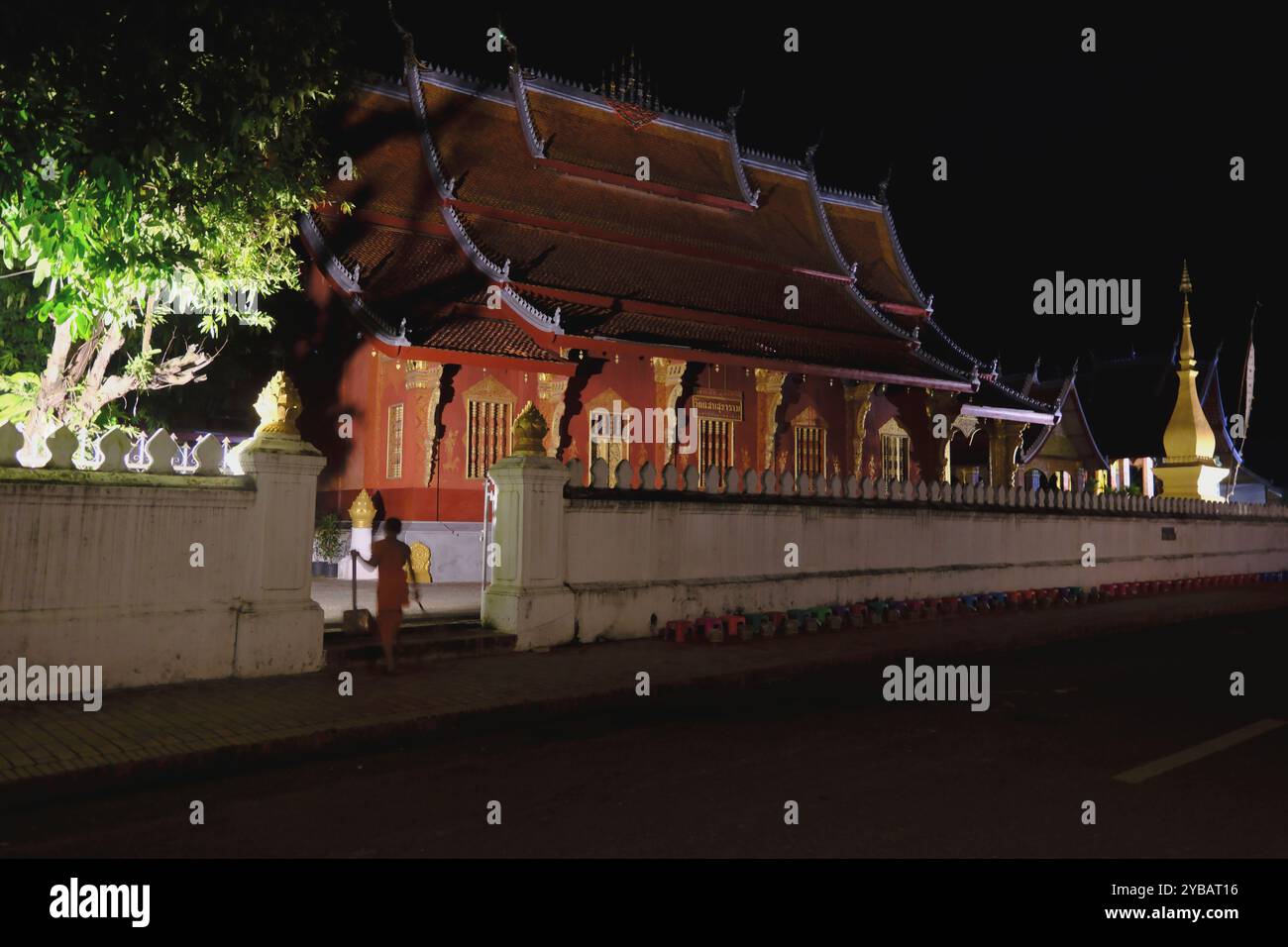 A young monk sweeping the entrance of Wat Sen Souk Haram temple aka Wat ...