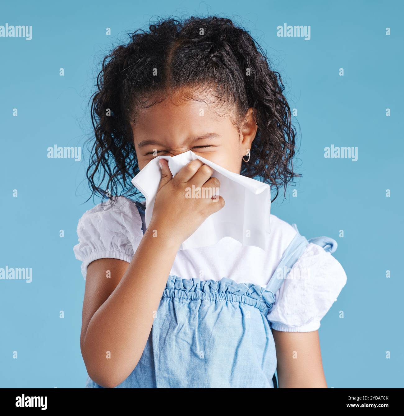 Girl, child and sneeze with tissue in studio, sick or cold with mucus, cleaning nose and hygiene ...