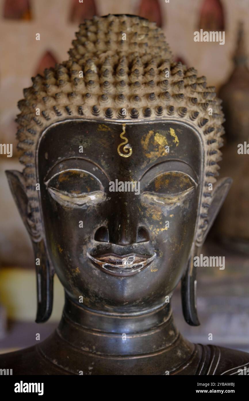 A closed up view of an ancient Buddha statue's head display in the cloister of Wat Si Saket ...