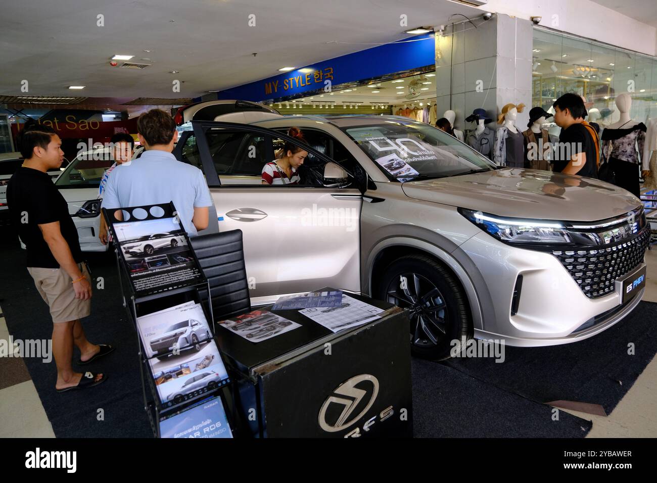 A car salesman showing a Chinese made Dfsk Fengon E5 PHEV SUV to ...