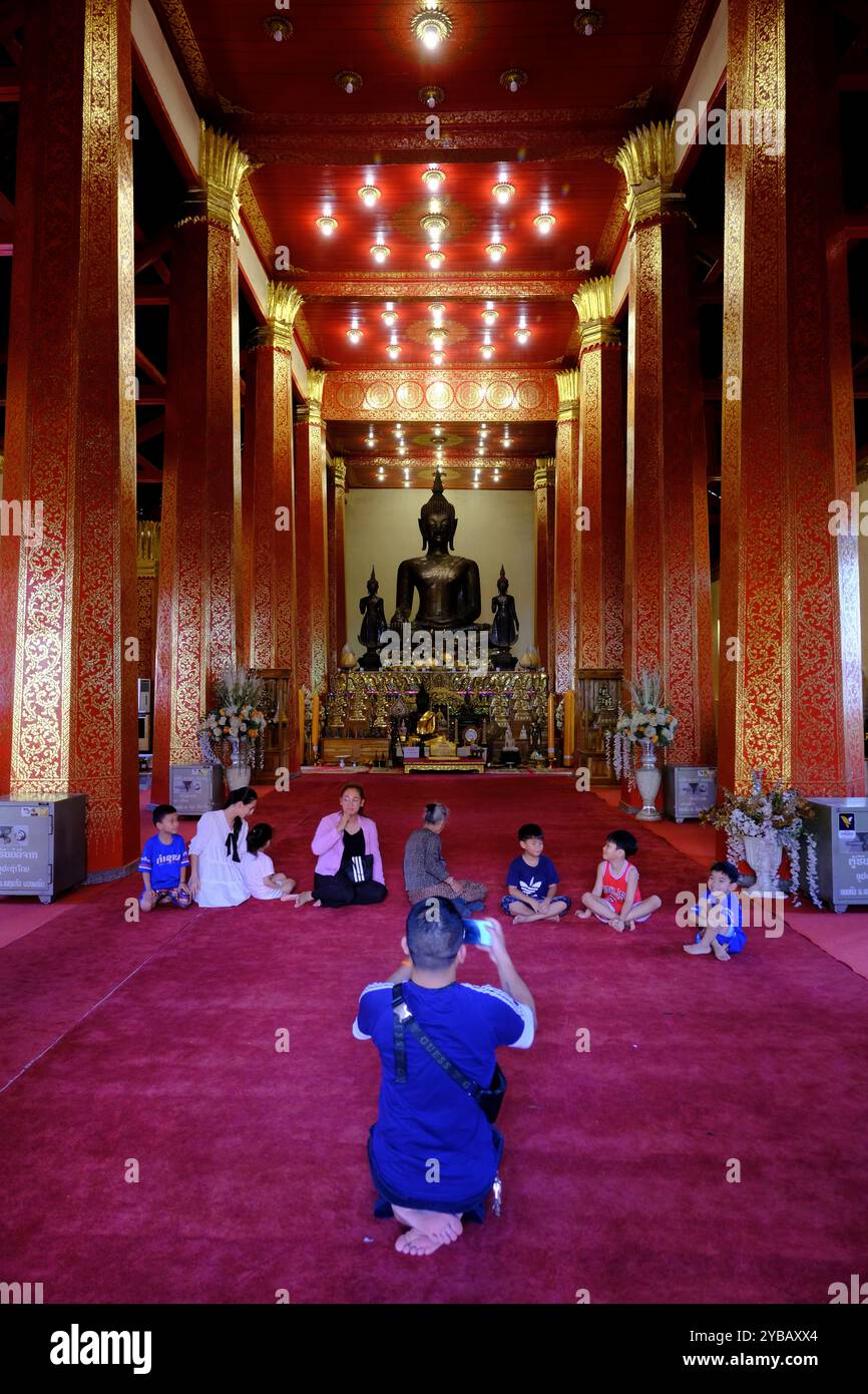 A family having their photos taken in front of Phra Ong Teu, the large ...