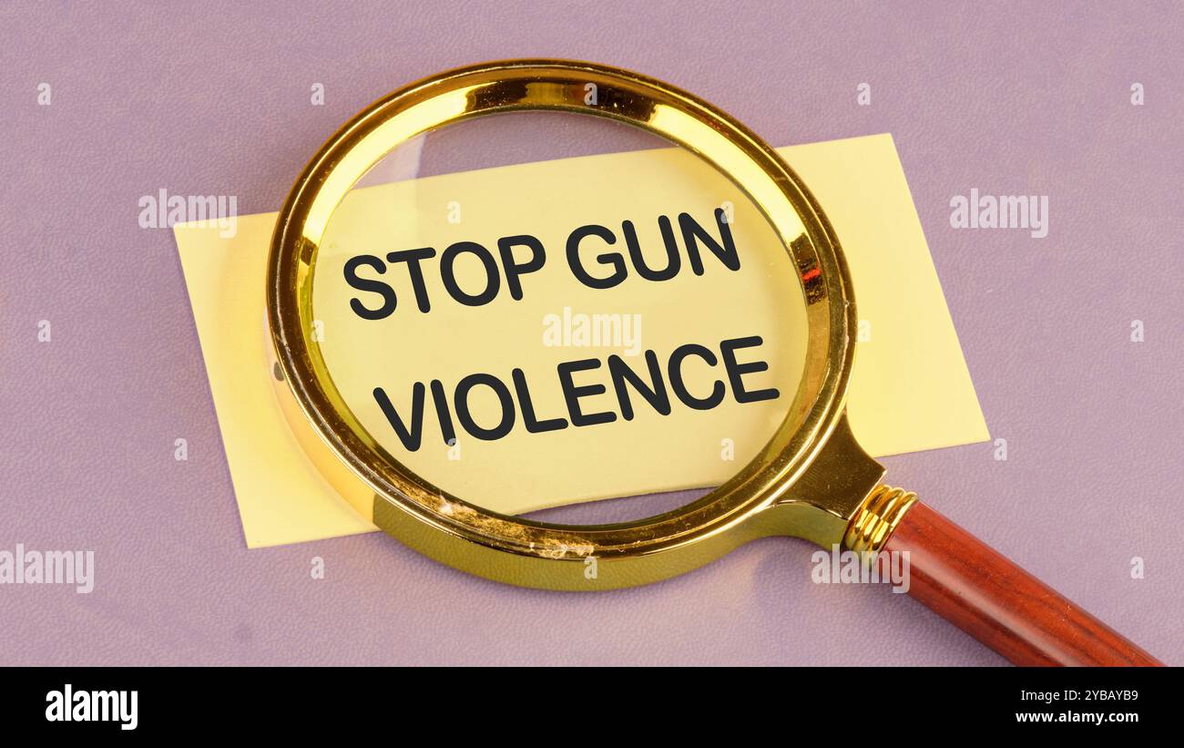 STOP GUN VIOLENCE text written on a yellow business card through a ...