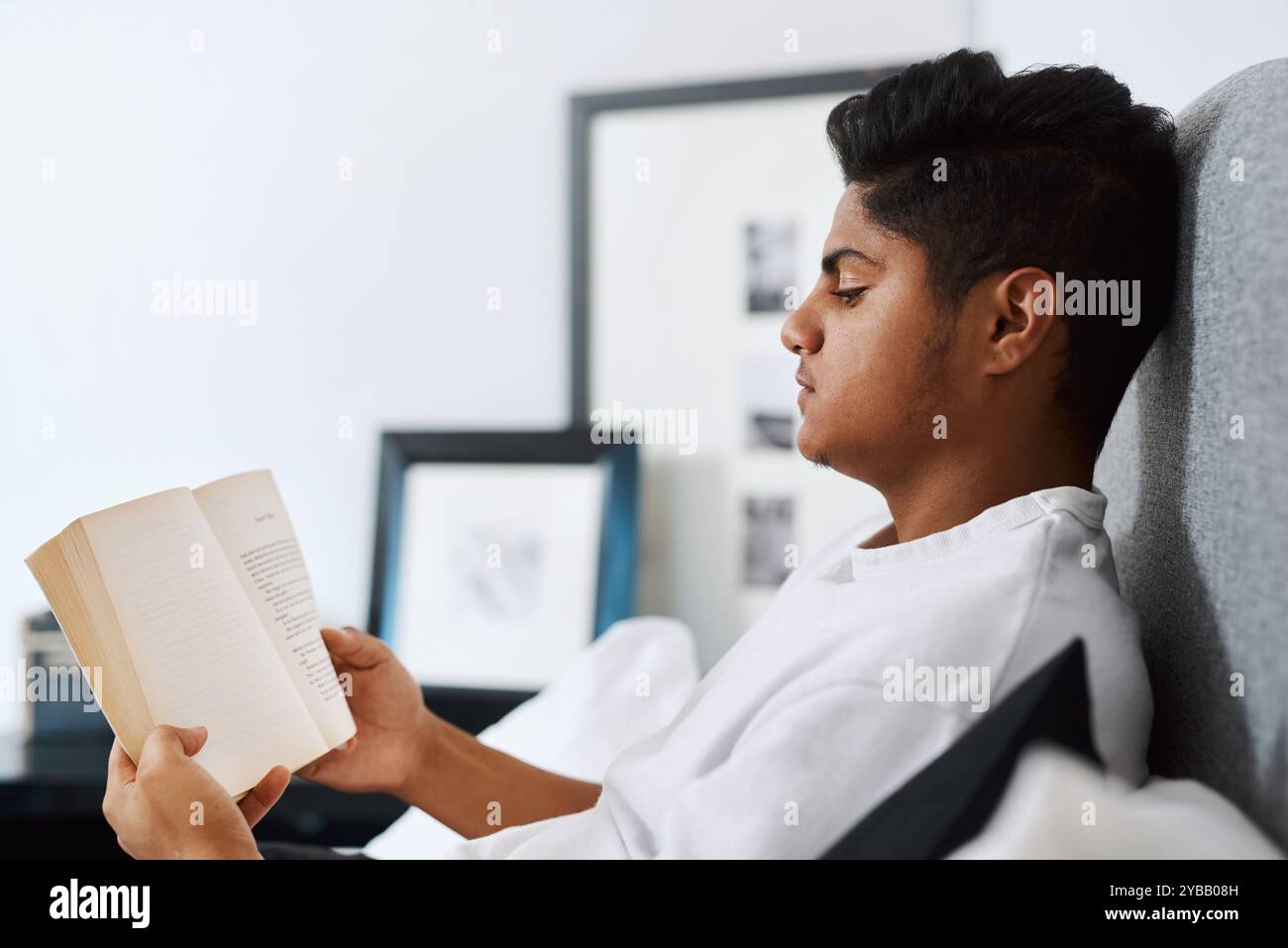 Relax, reading and man with books in bedroom for learning, knowledge ...
