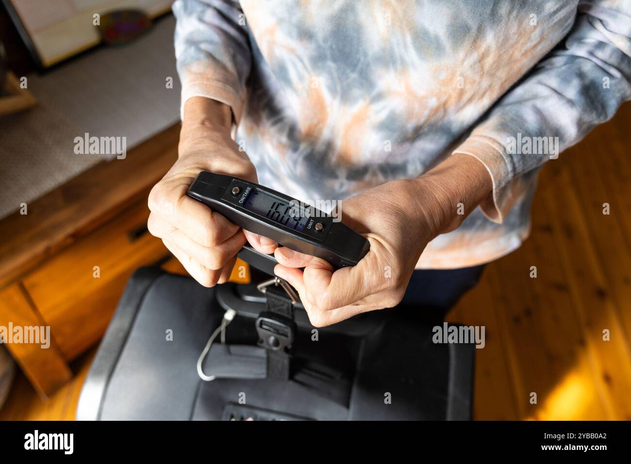 Woman weighing luggage hand scales hi-res stock photography and images ...