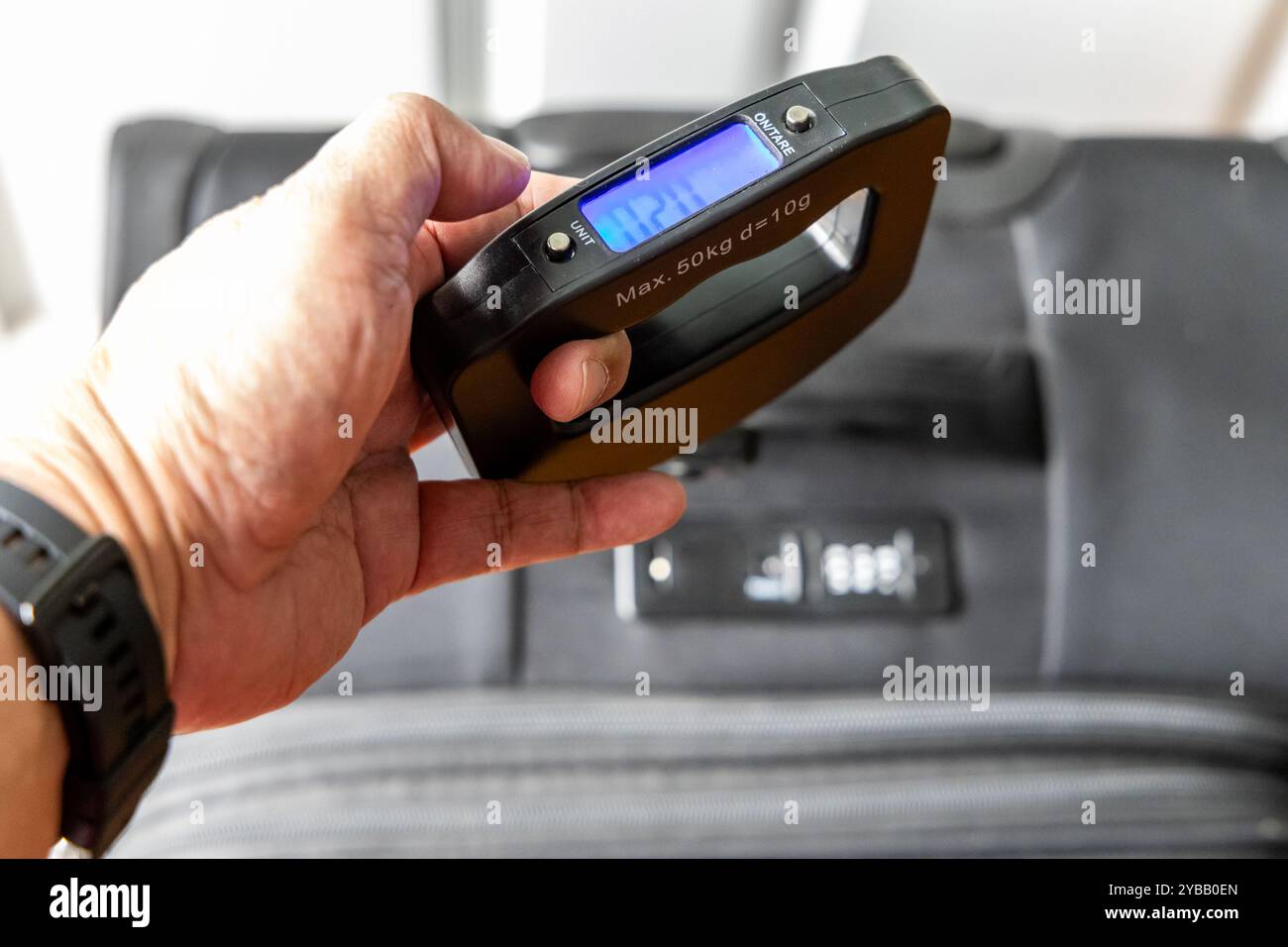 Perspective view of hand holding digital weighing scale to ascertain ...