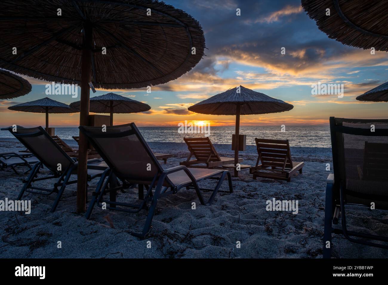 Empty sun beds on the beach at the end of a beautiful day with stunning ...