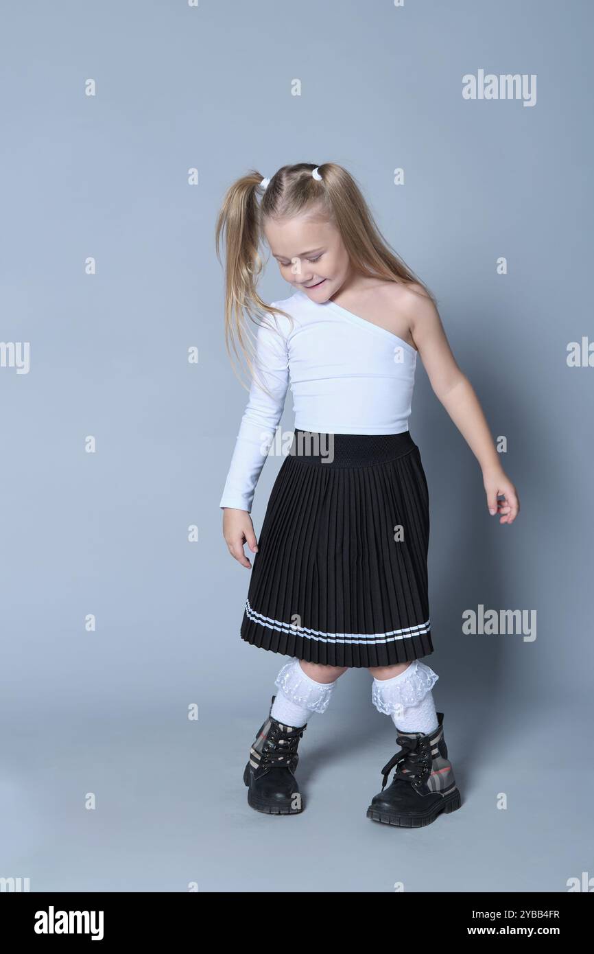 young girl, full of energy and playfulness, poses with a cheeky ...