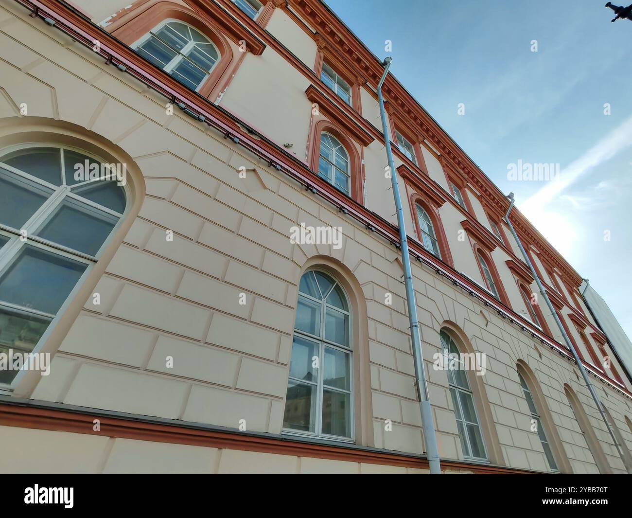 large yellow building with multiple windows and an arched doorway ...