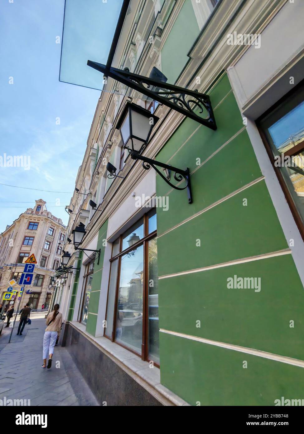 green storefront with expansive windows and decorative iron lanterns ...