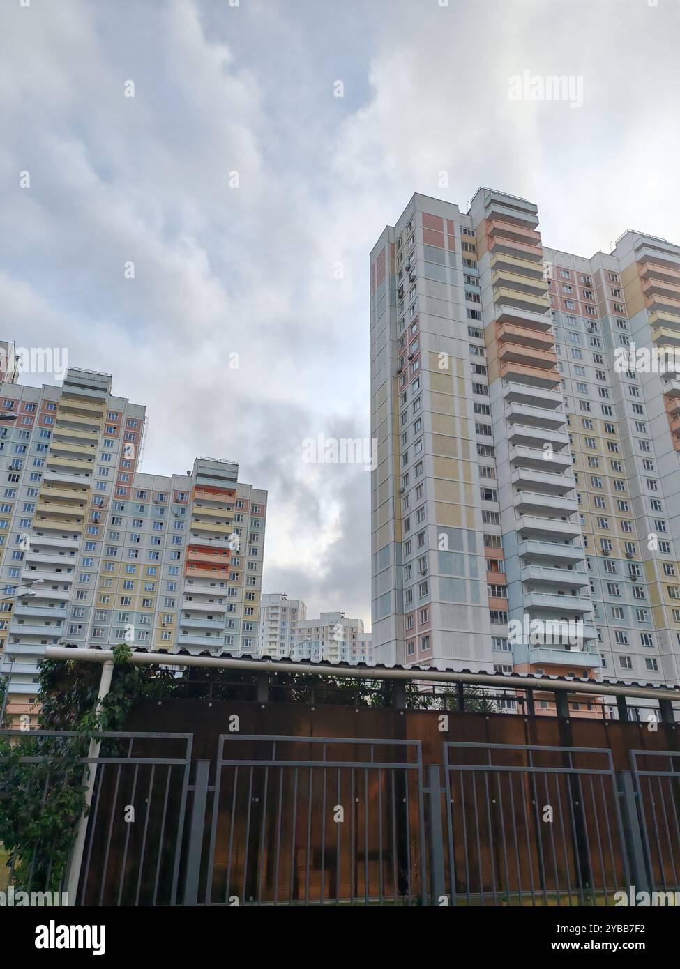 A tall apartment building with pastel-colored balconies and windows ...