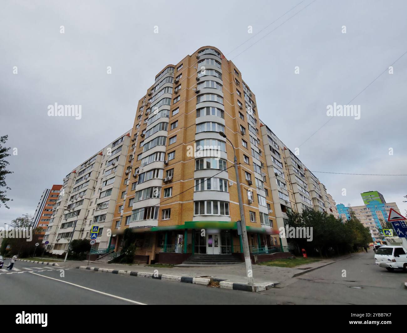 A pastel-colored high-rise residential building with curved balconies ...