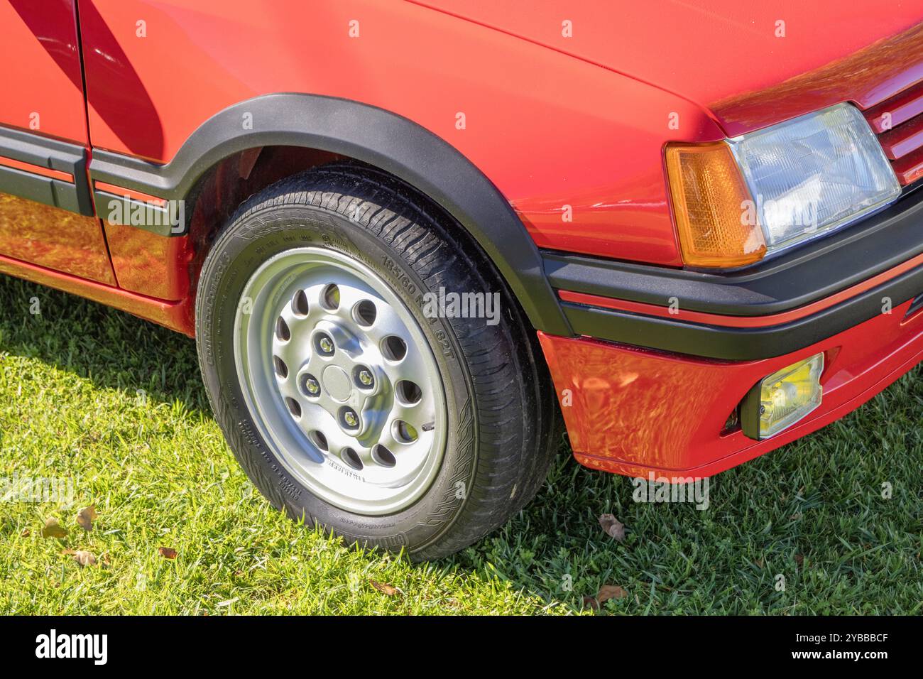 Red peugeot 205 gti parked on a grass field with the focus on the front ...