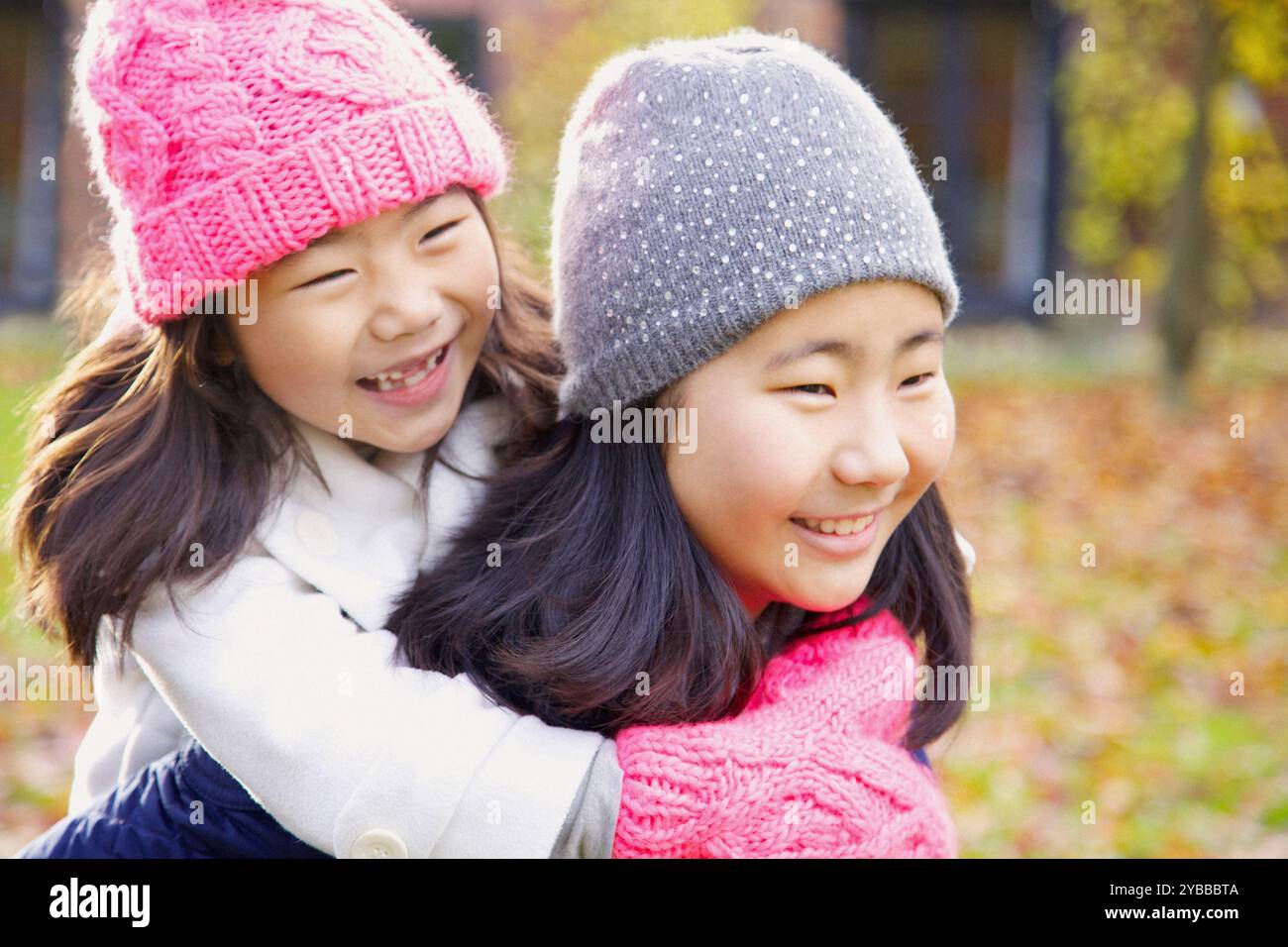 Two Young Girls Riding Piggyback Outdoors Stock Photo - Alamy