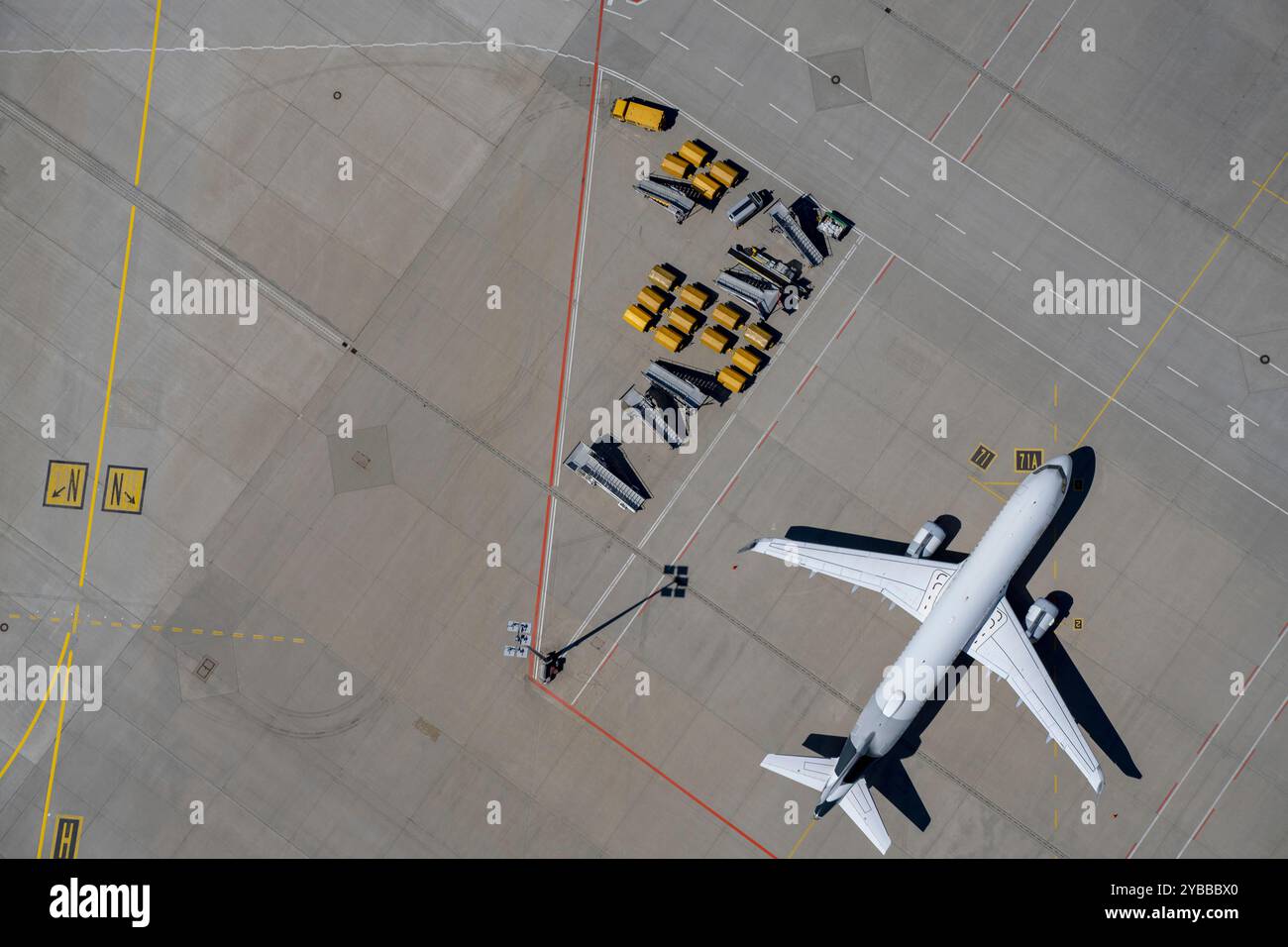 View from above airplane and luggage carts on sunny airport tarmac ...