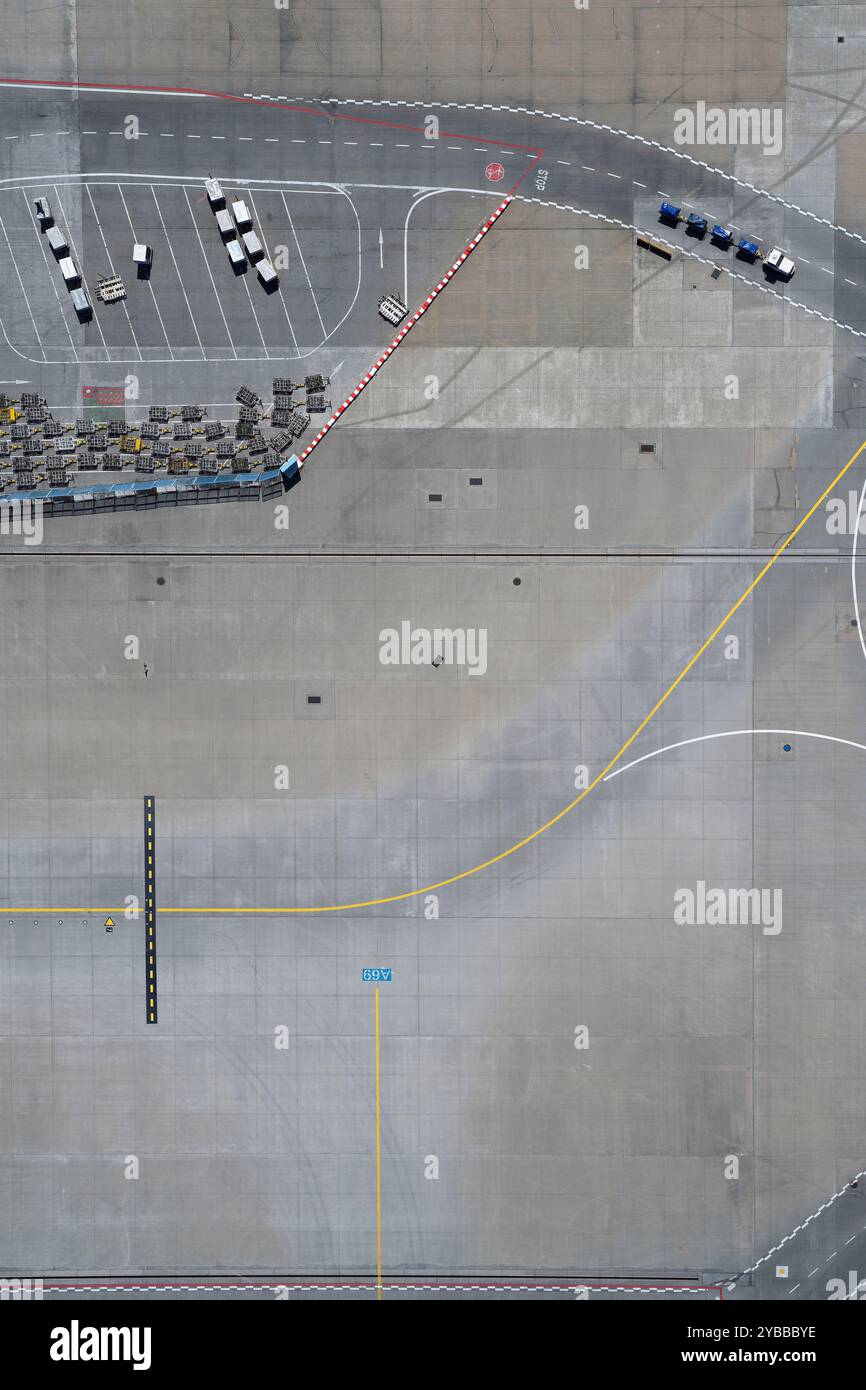 View from above luggage carts and road markings on sunny airport tarmac ...