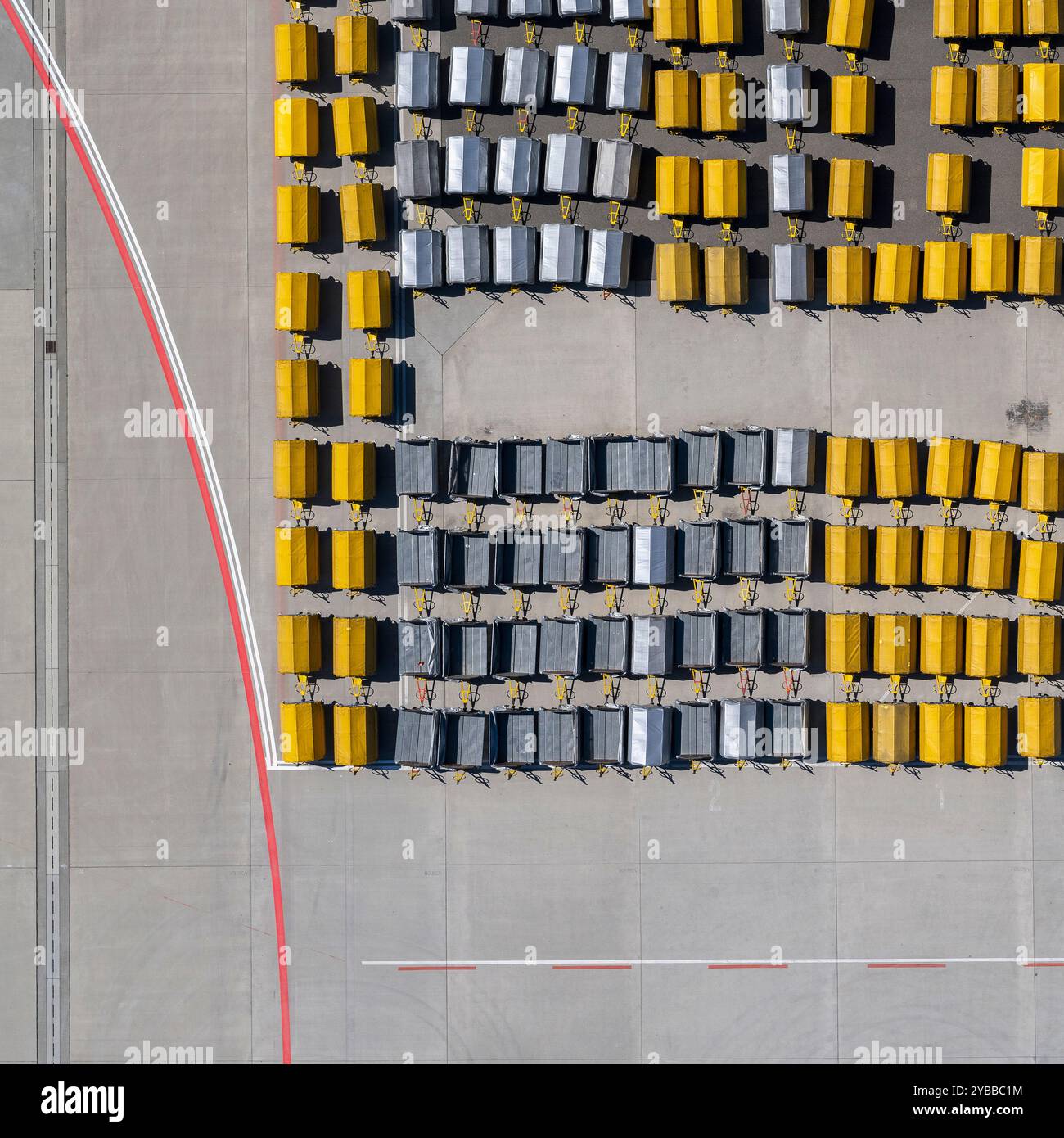 View from above empty yellow and black luggage carts in rows on sunny ...