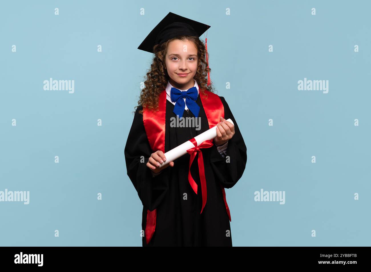 Young girl in graduation attire holding a diploma, looking confident ...