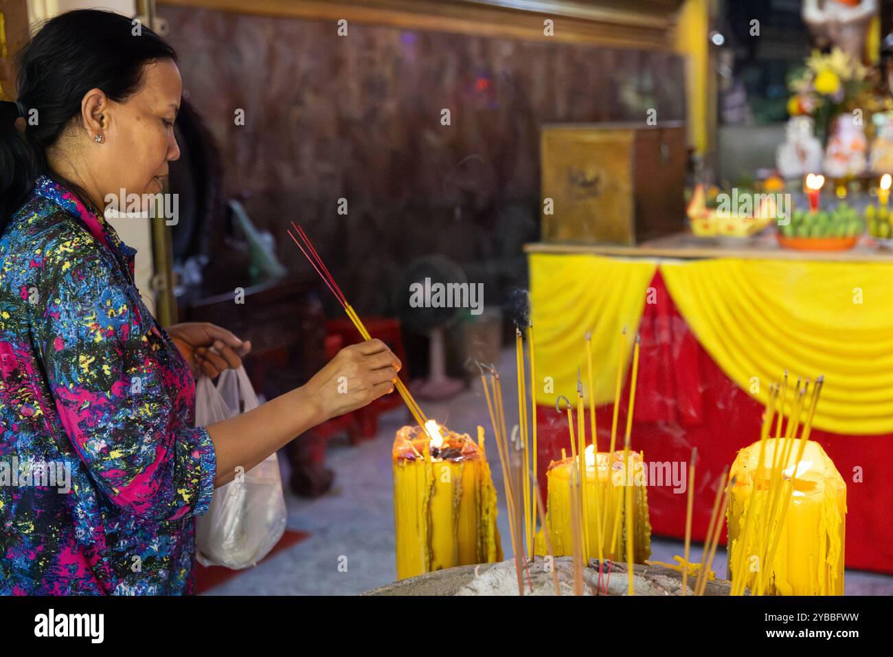 Visitor lighting incense sticks at Wat Phnom, Phnom Penh, Cambodia ...