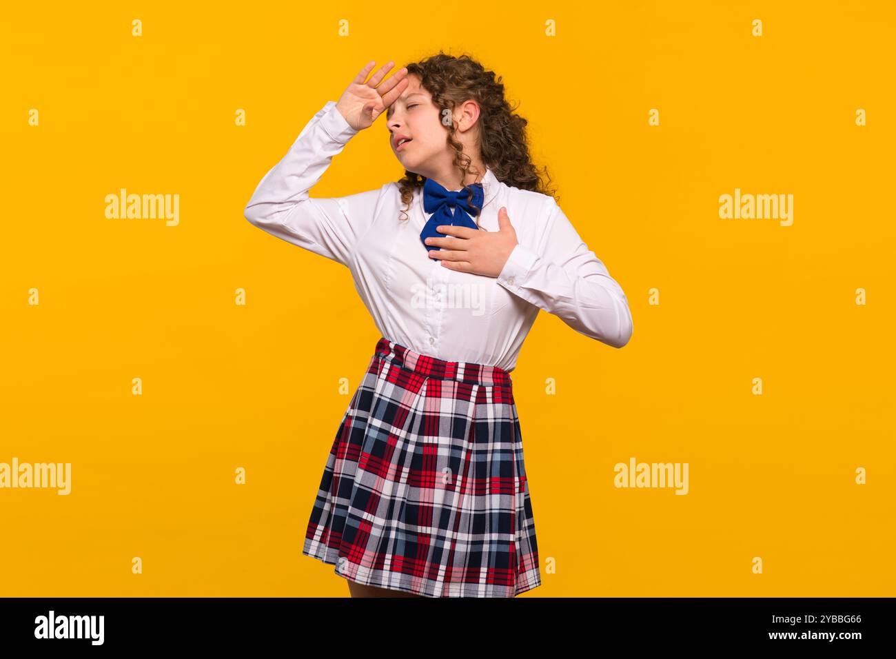 Girl in school uniform posing dramatically with hand on forehead ...