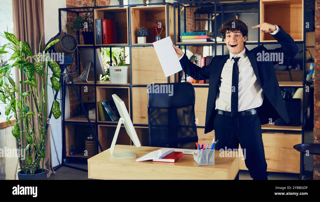 Successful deal. Happy young man, worker in formal wear standing in ...