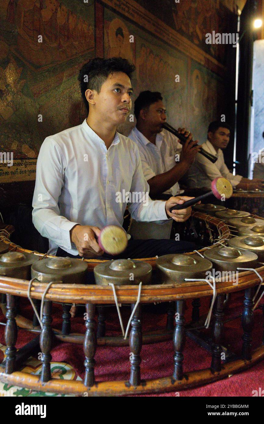 Playing Cambodian traditional musical instrument Kong toch at Wat Phnom ...