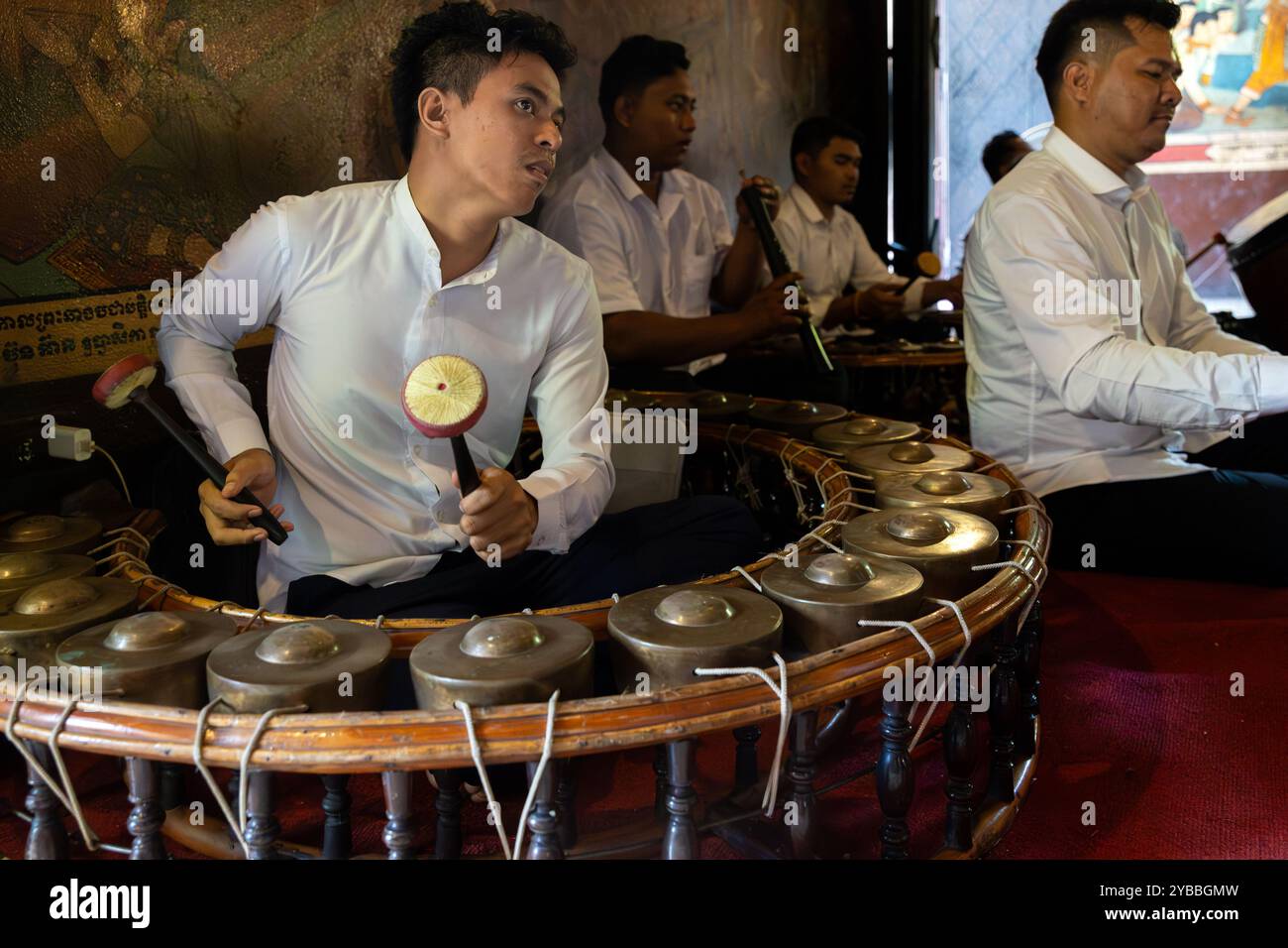 Playing Cambodian traditional musical instrument Kong toch at Wat Phnom ...