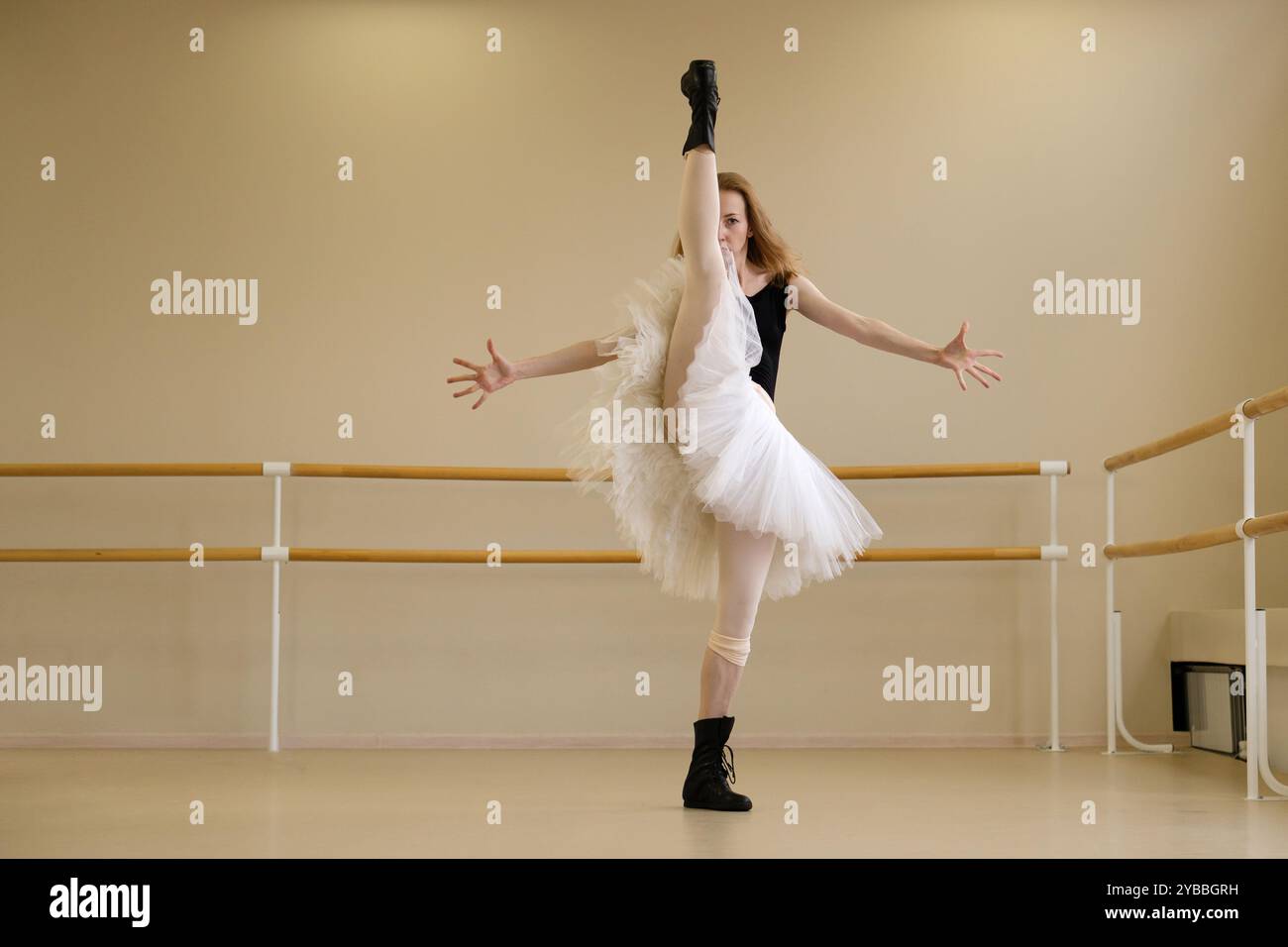 Ballerina in shoes and tutu, balancing with arms wide in modern dance ...