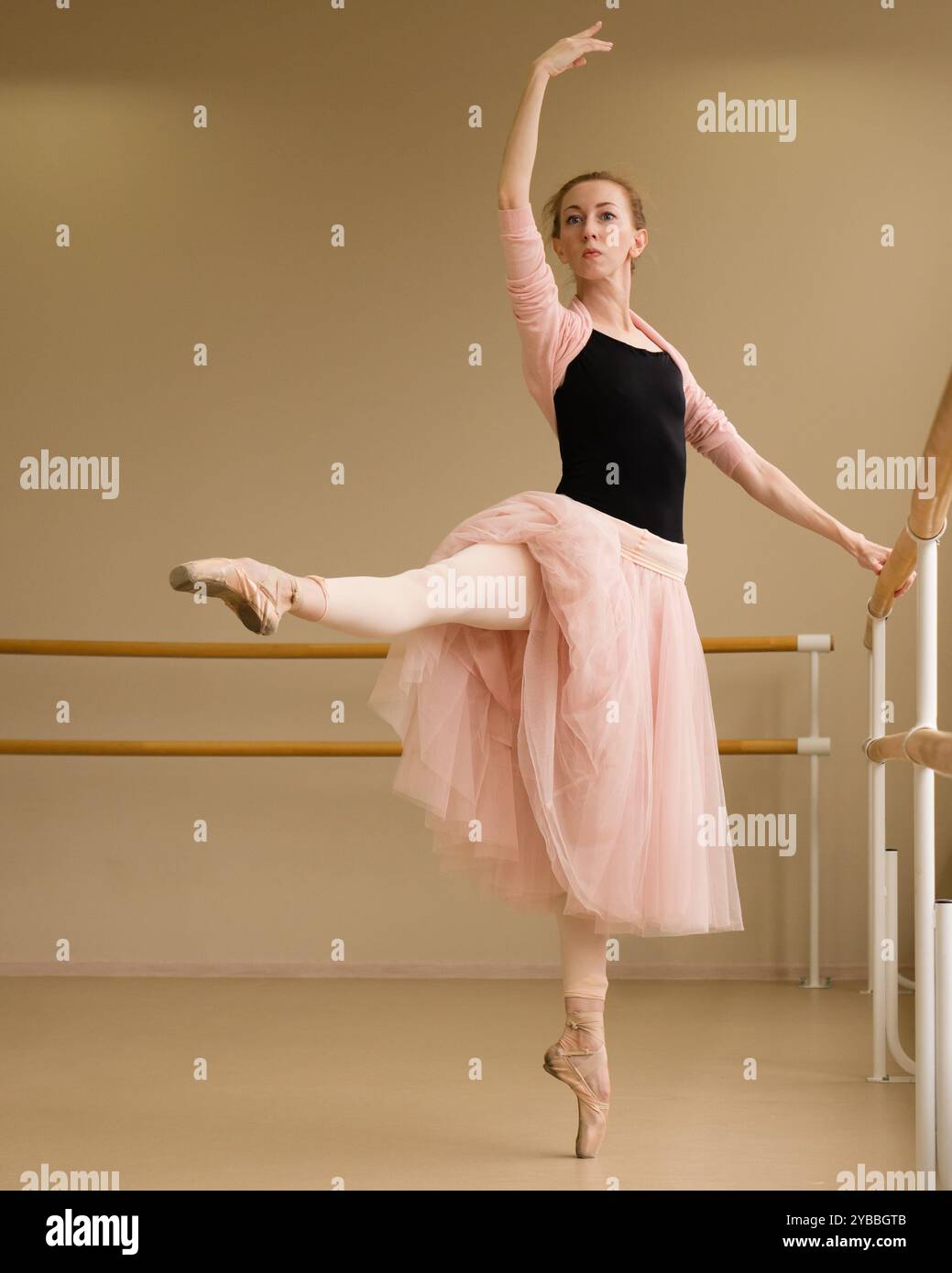 Ballet dancer performing a high leg extension en pointe, with arm ...