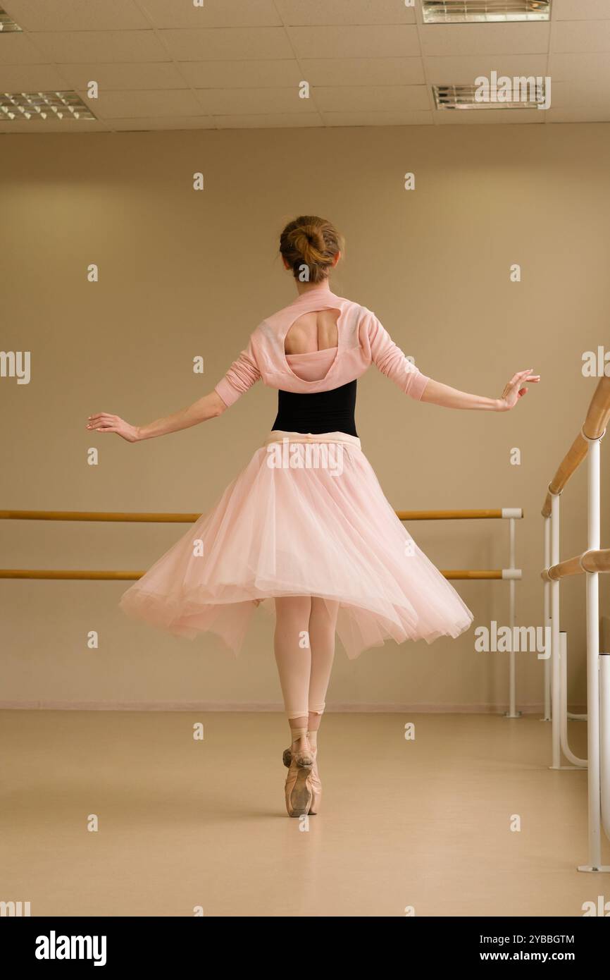 Ballet dancer performing a pirouette en pointe, with graceful arm ...