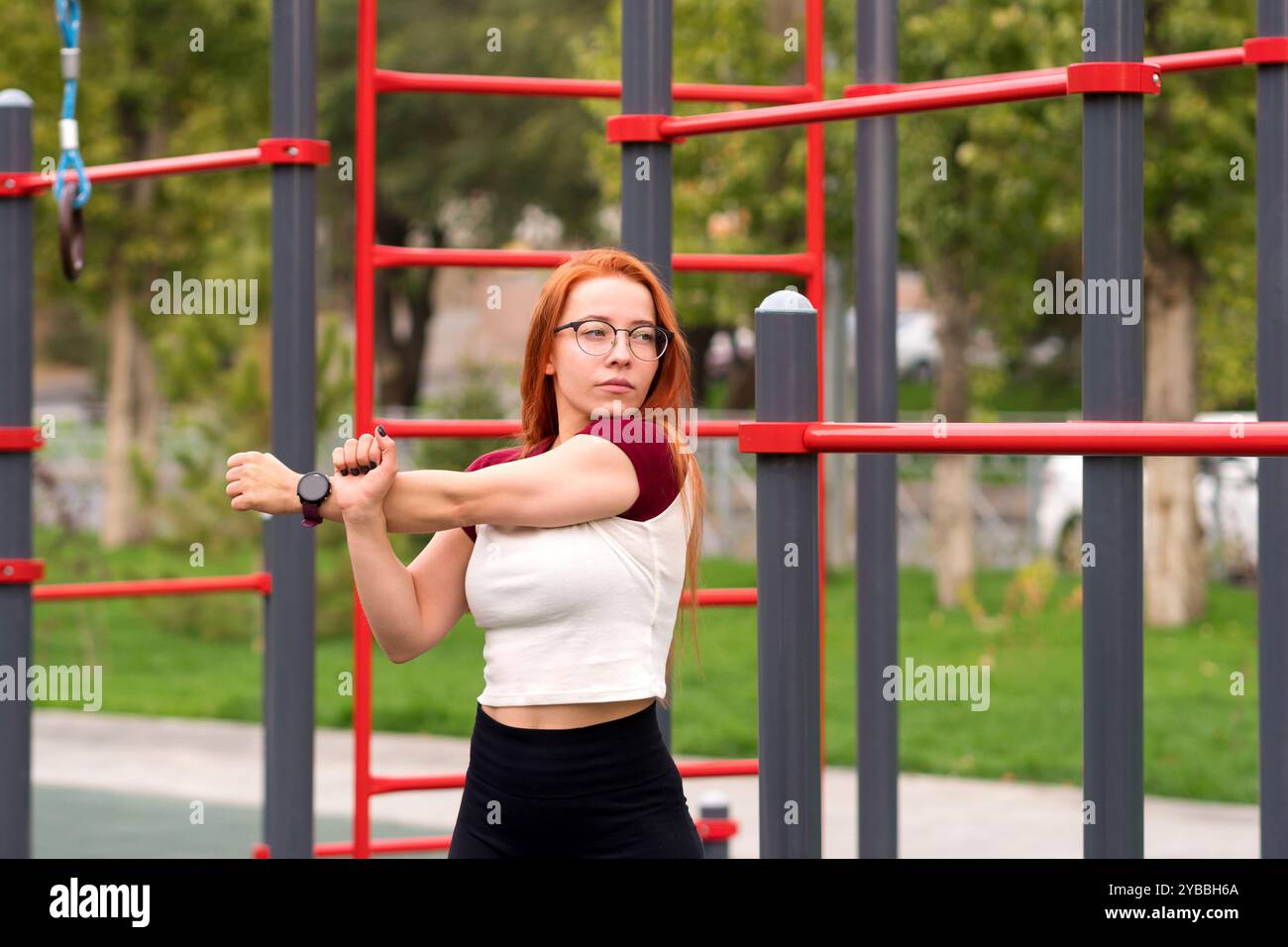 Woman performing arm stretches as part of her warm-up routine at an ...