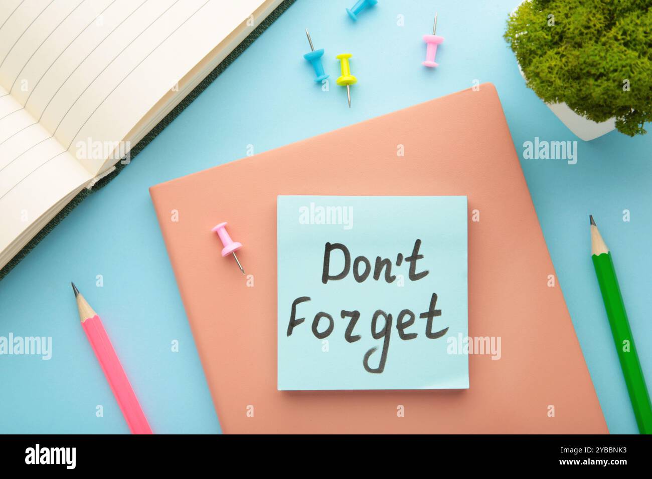 Open notepad and sticky notes with word don't forget on blue background ...