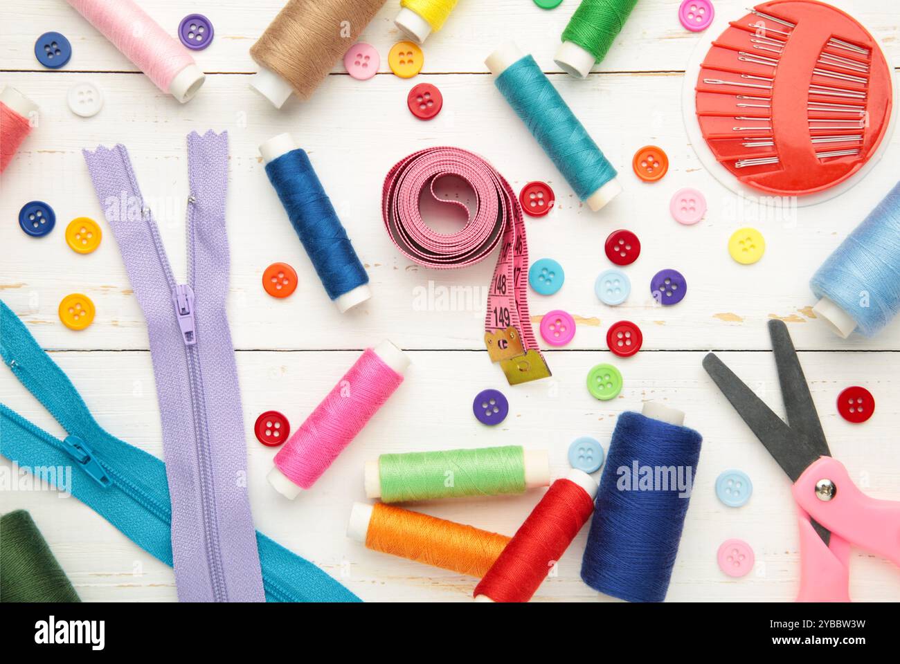 Sewing supplies on white background: sewing thread, scissors, a large ...