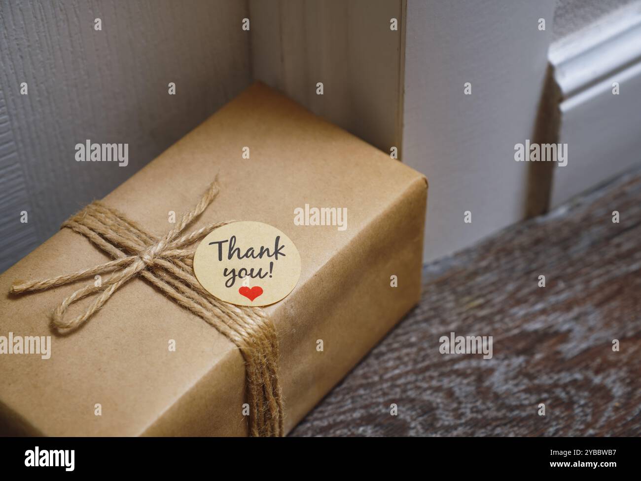 Gift box with Thank you sticker placed next to the door Stock Photo - Alamy