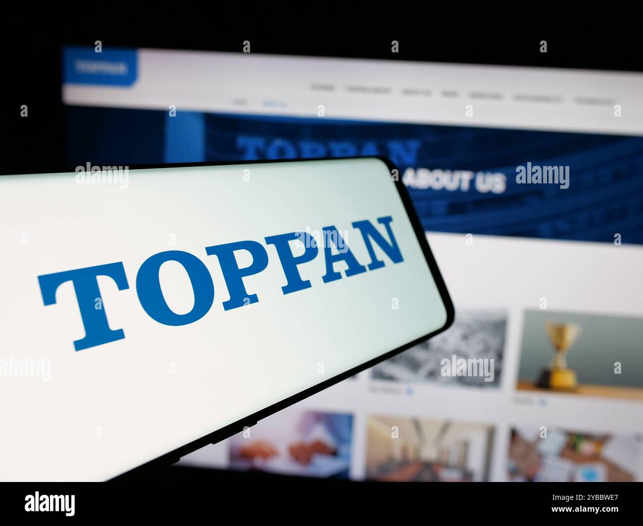 Smartphone with logo of Japanese company Toppan Holdings Inc. on screen in front of business ...
