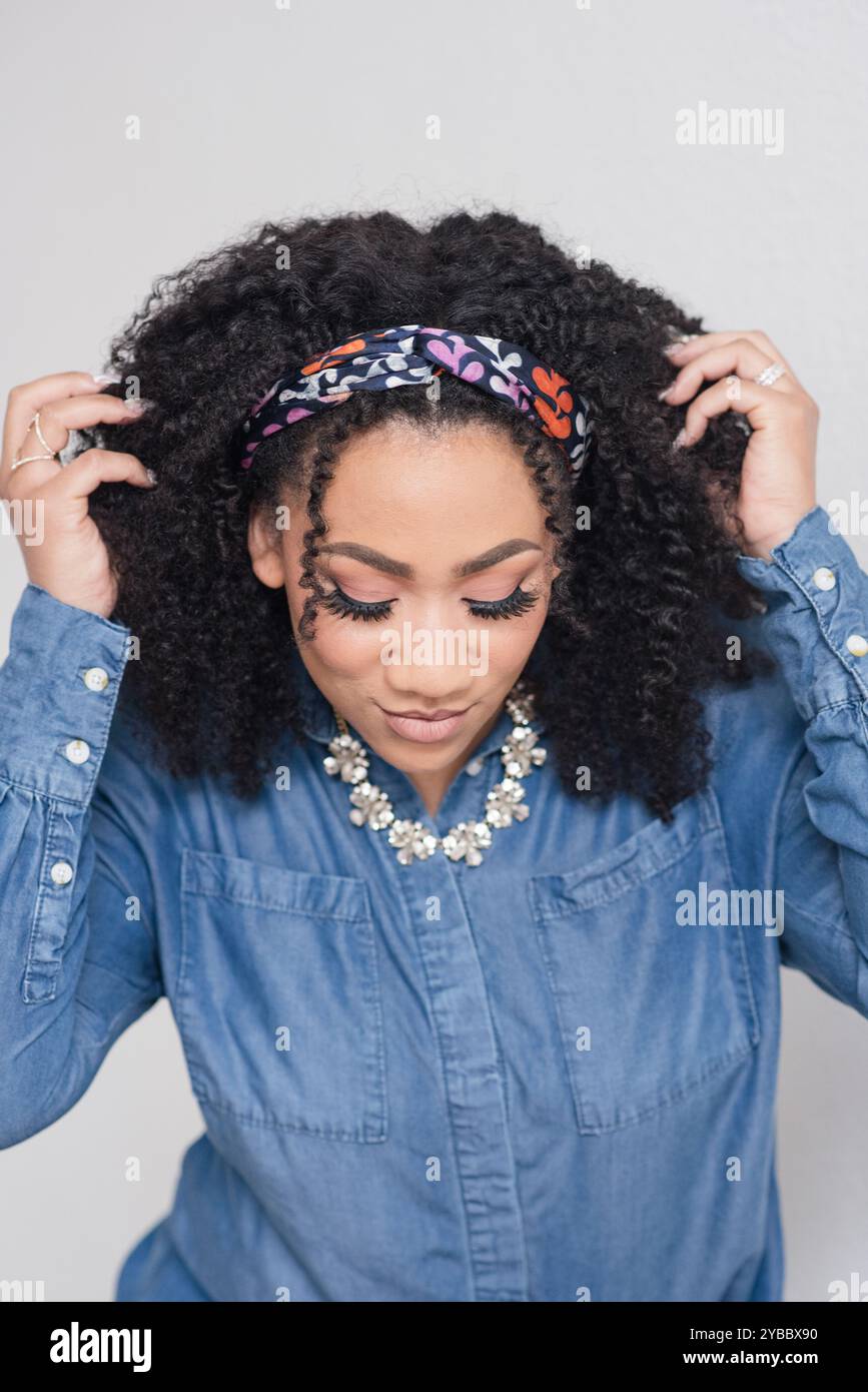 Woman looking down with long lashes holding her curly hair Stock Photo ...