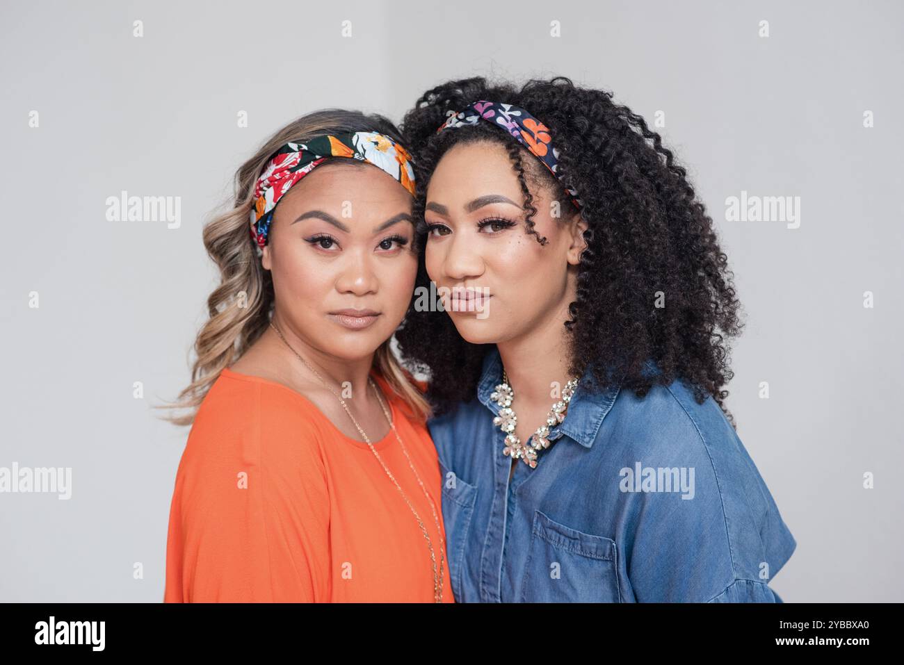 Two women with head bands looking at the camera Stock Photo - Alamy